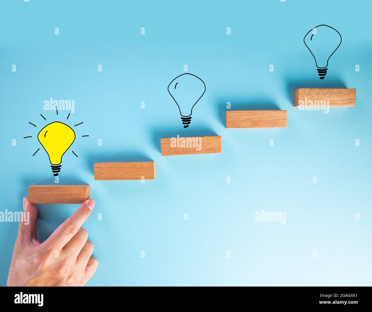 Developing new idea on wooden steps with male hand placing the last ...