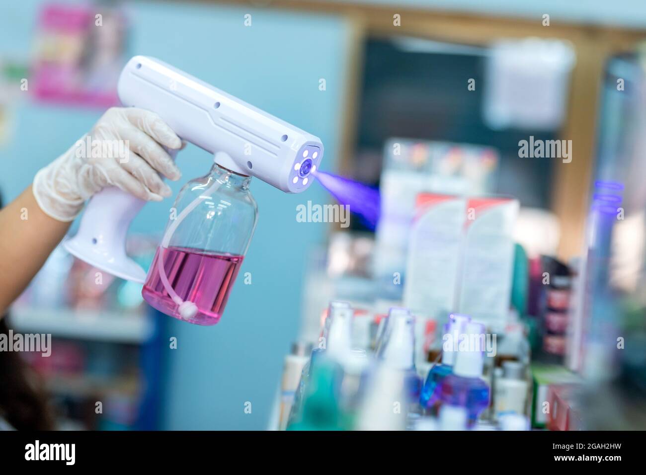 close up hand of staff wearing gloves using electric Alcohol Nano Spray ...