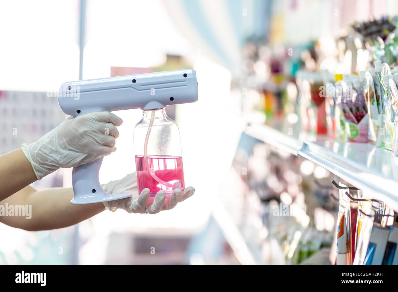 close up hand of staff wearing gloves using portable usb nano sanitizer ...