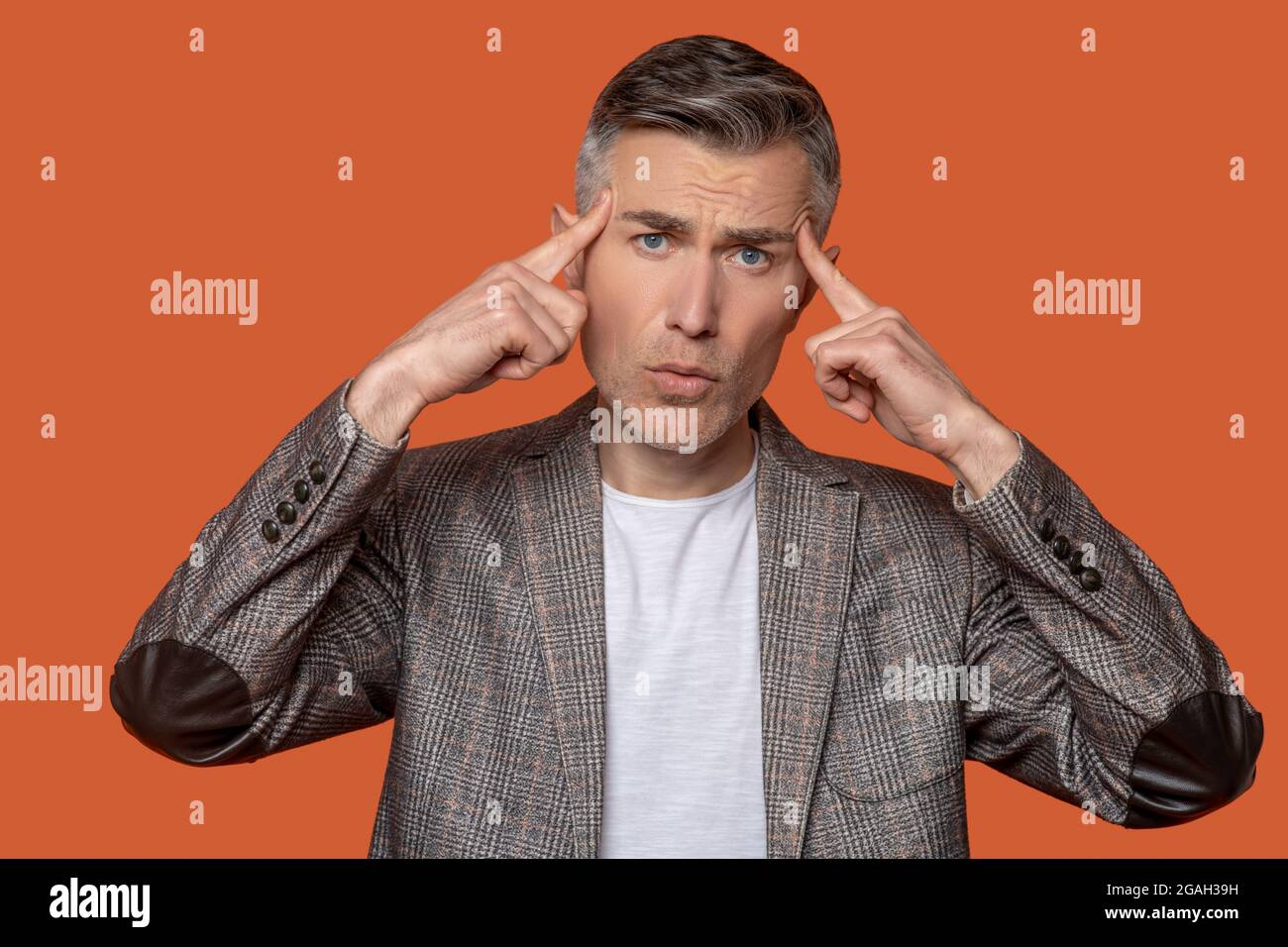 Man touching head with his fingers Stock Photo - Alamy