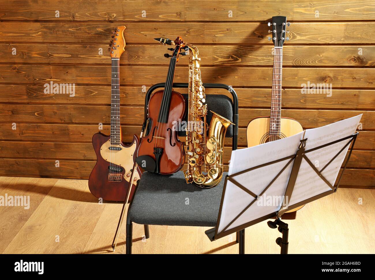 Musical instruments on a chair and note holder against wooden ...