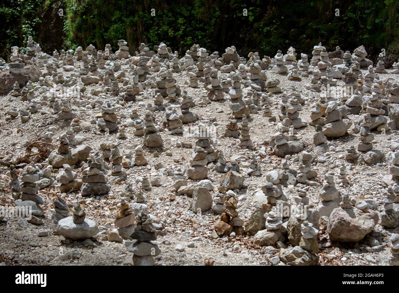 Stone towers and piles of stones on a river bank. Stacked rocks forming ...