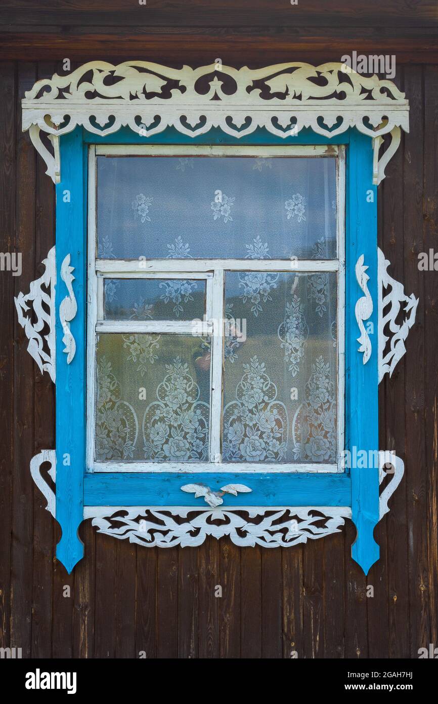Old Russian window with carved frame with wooden wall. Tulle curtains ...