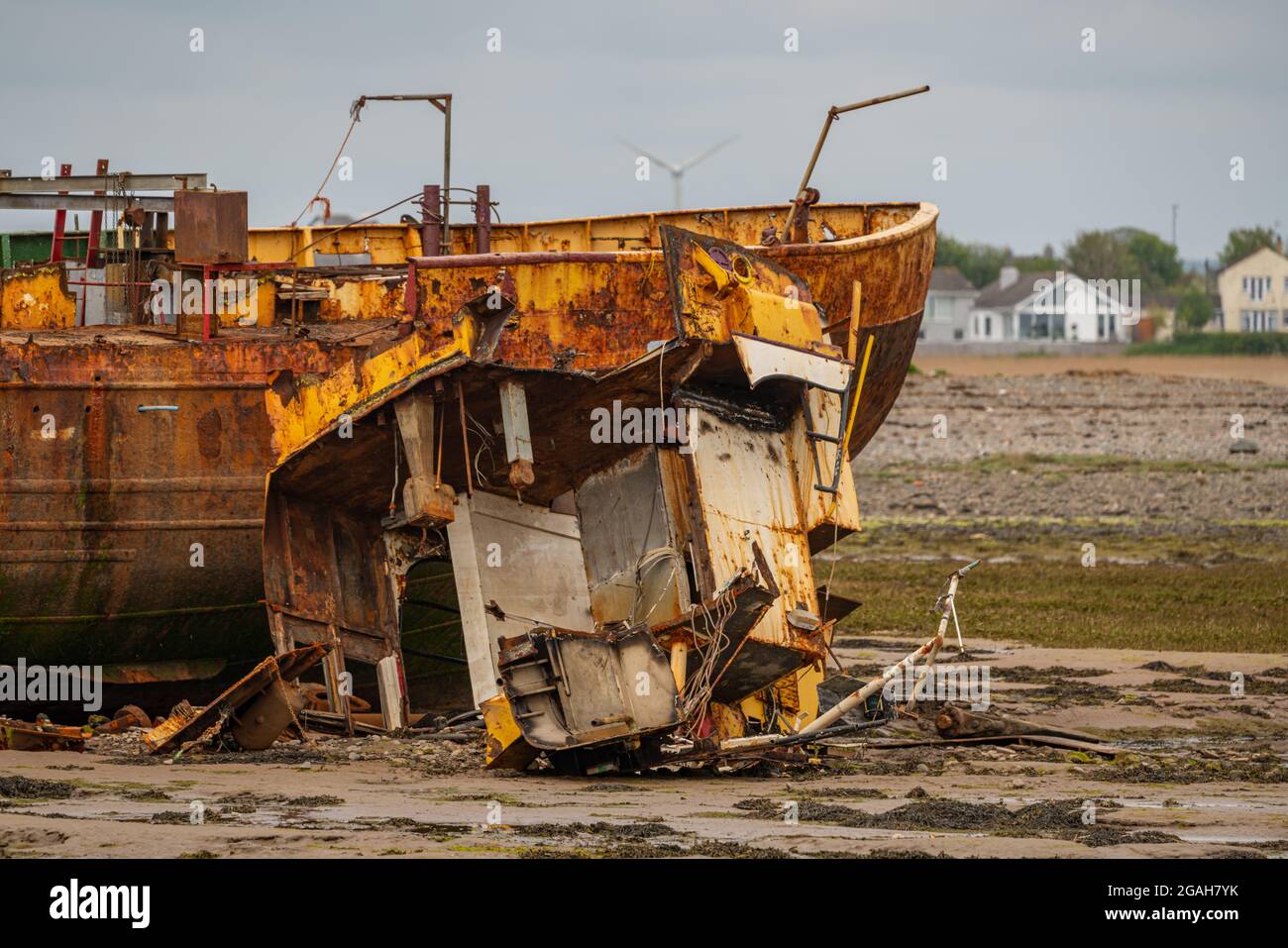 A rusty shipwreck in the mud of the Walney Channel, seen from the road ...