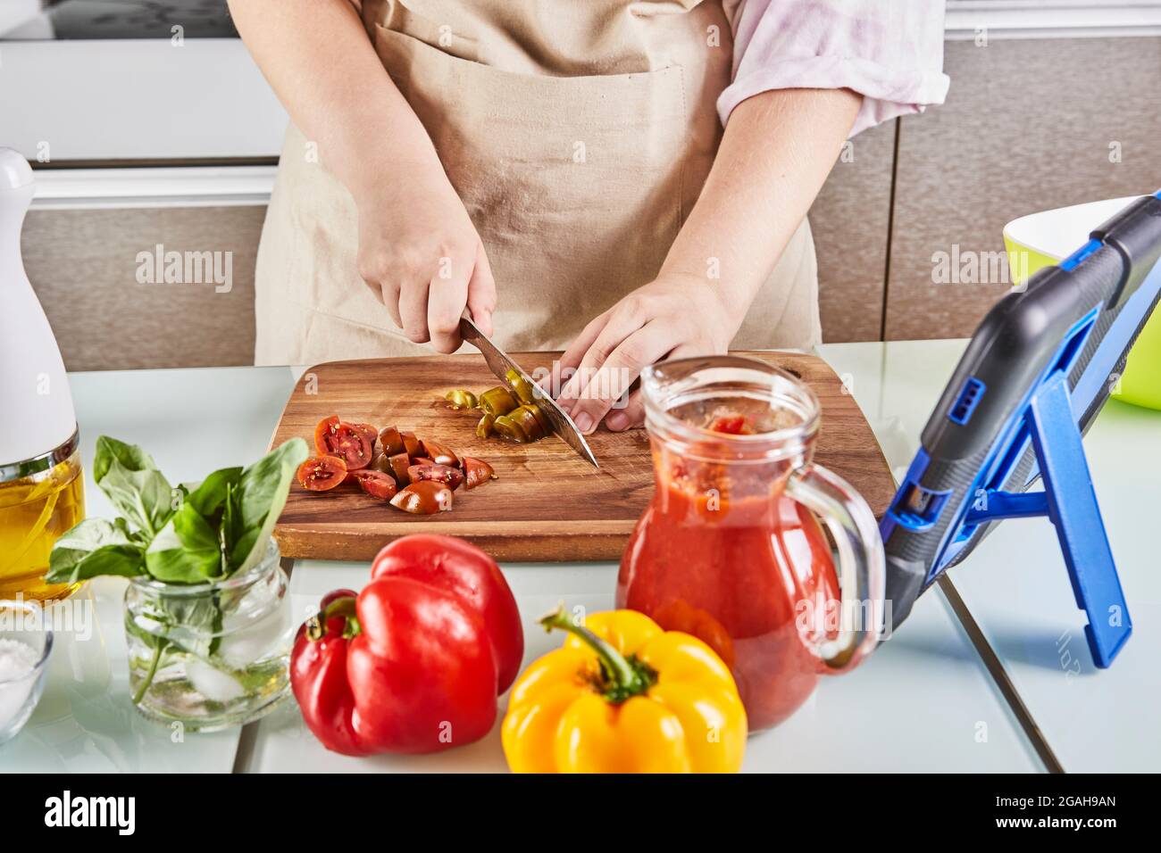 Teenager prepare spaghetti bolognese from an online textbook and ...