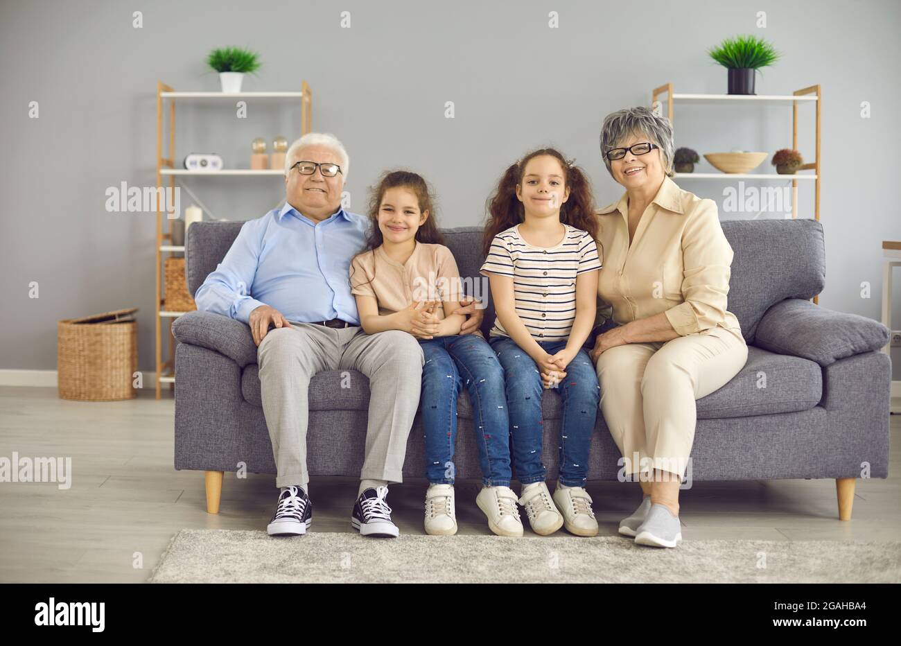 Portrait of happy grandparents and little grandchildren sitting on the ...