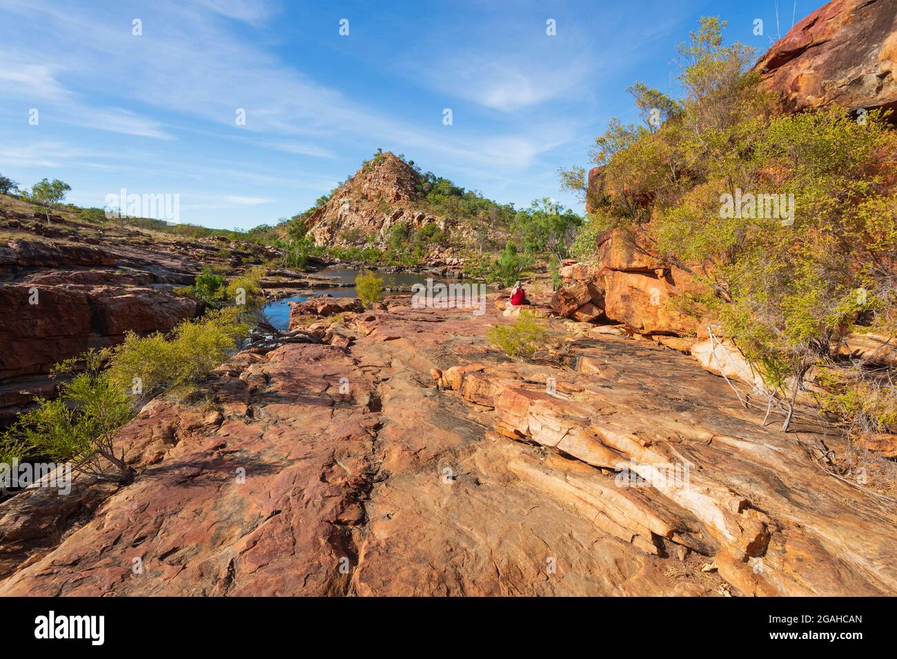 Tourist wearing a red t-shirt sat at Bell Gorge, a renowned destination ...