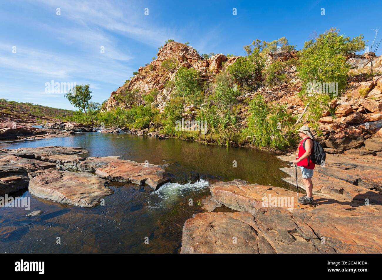 Hiker wearing a red t-shirt looking at Bell Gorge, a renowned ...