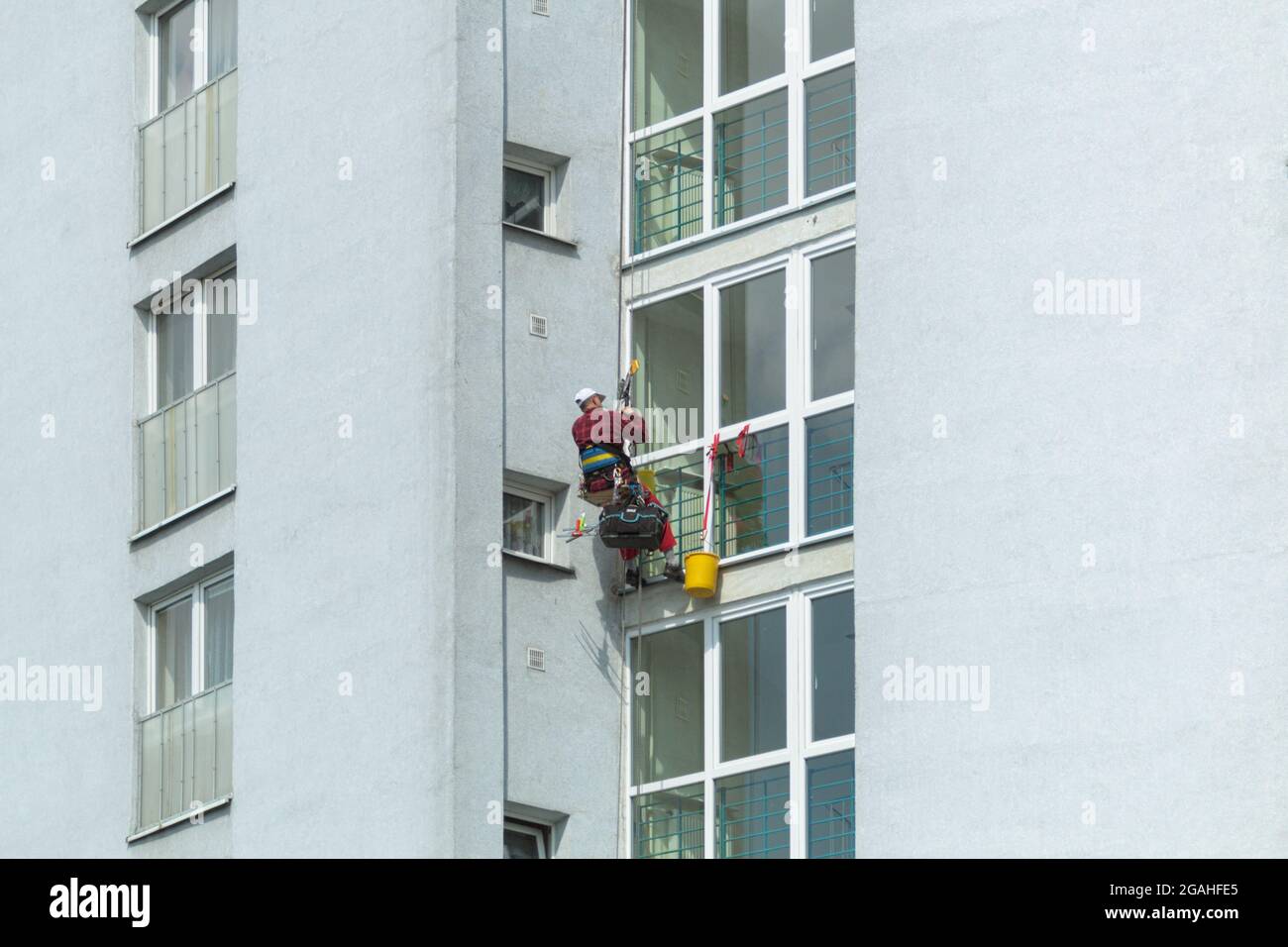 A man washes windows in a multi-storey building. Professional window ...
