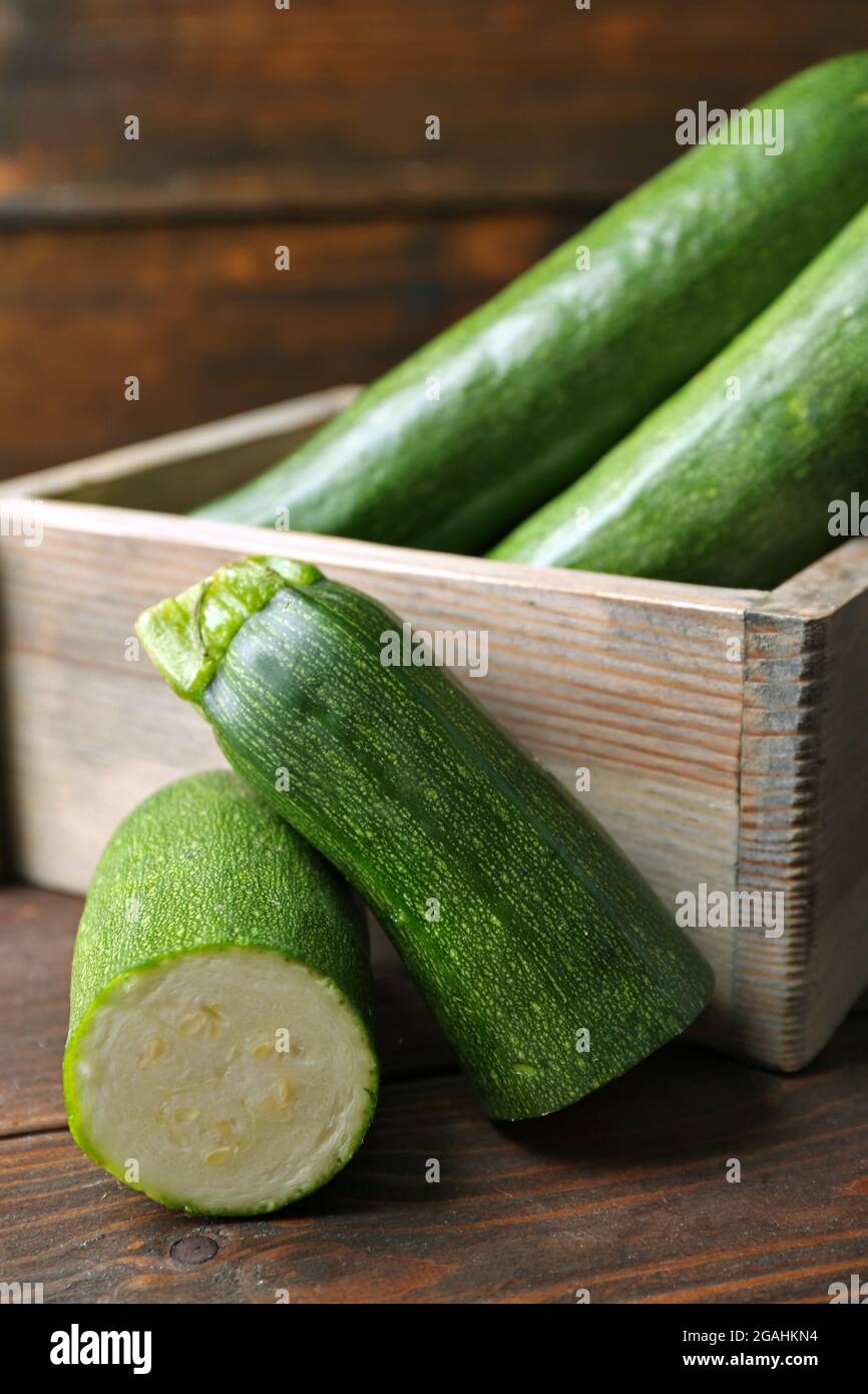 Fresh zucchini in box on wooden background Stock Photo - Alamy