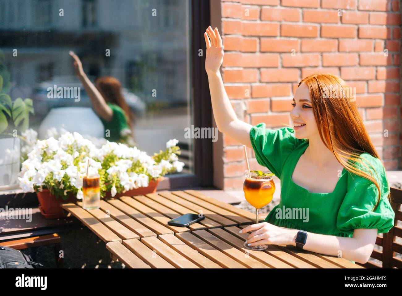 Happy smiling young woman raising hand in sign of salute, greeting ...