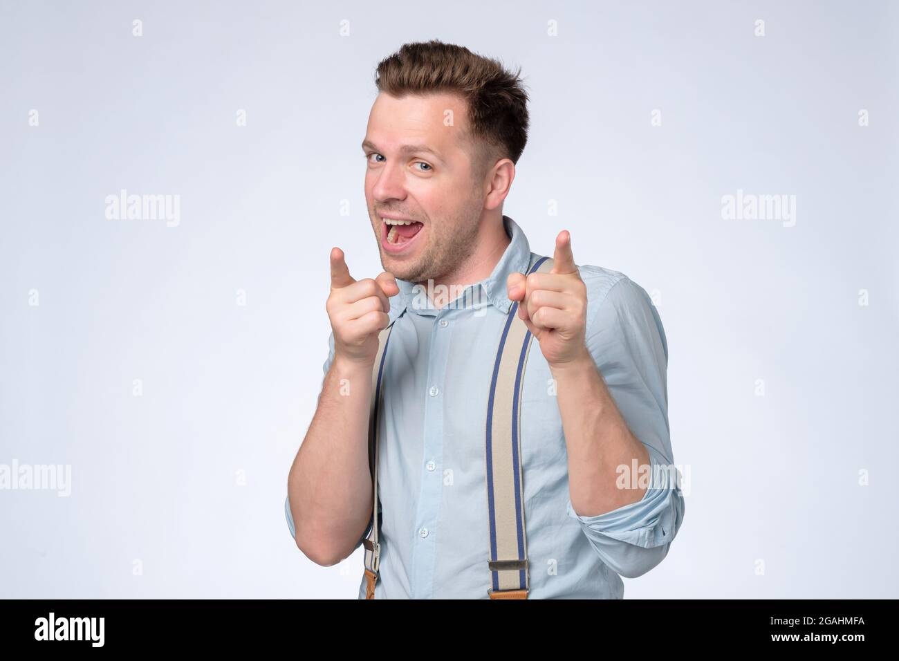 Young handsome man pointing fingers to camera with happy and funny face ...
