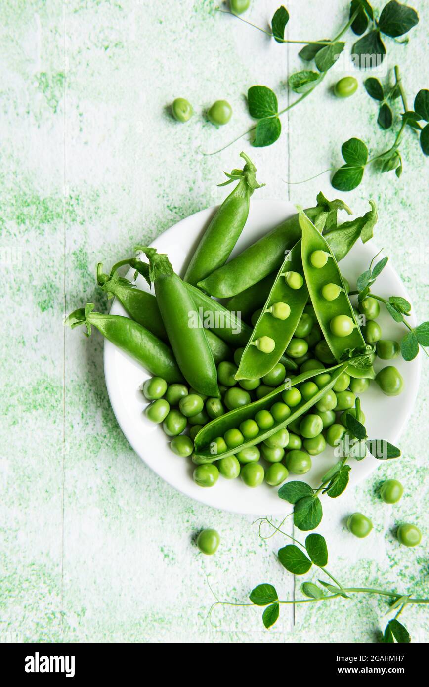 Fresh green peas pods and green peas with sprouts on green wooden ...