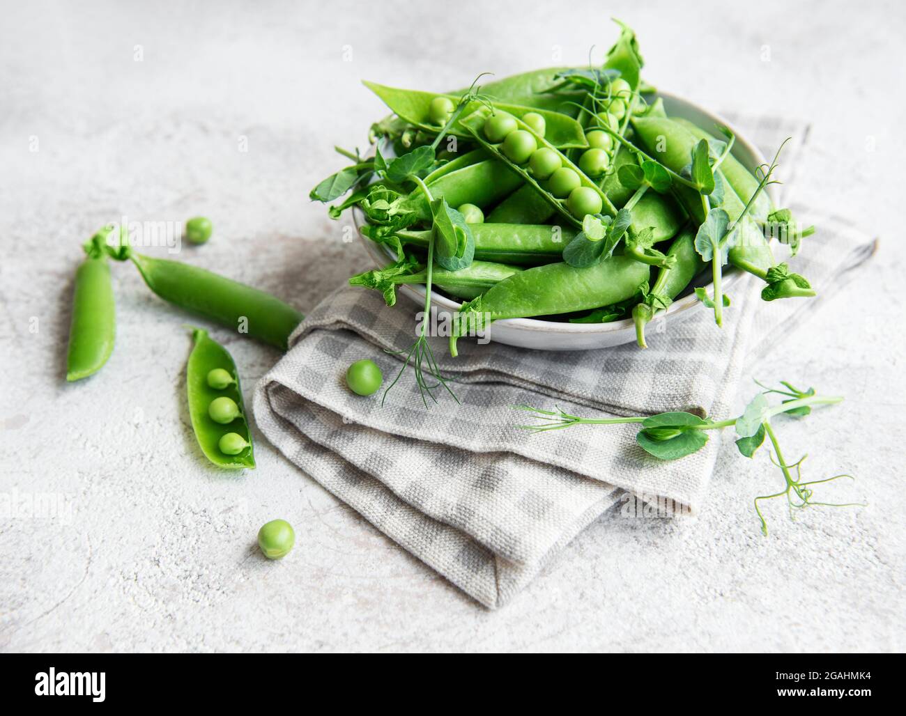 Fresh green peas pods and green peas with sprouts on concrete ...