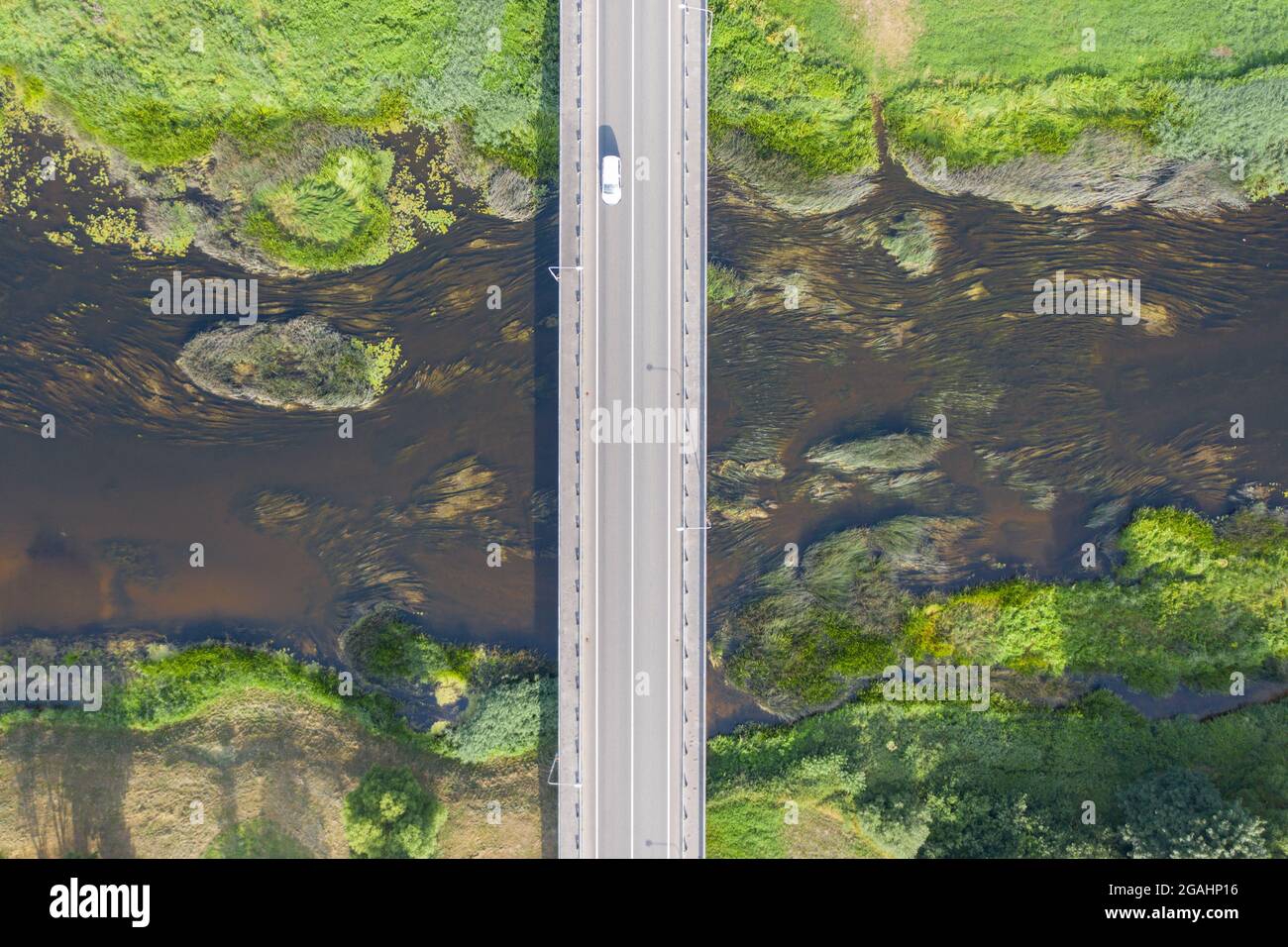 Aerial top down view of car driving over bridge. River flowing under ...