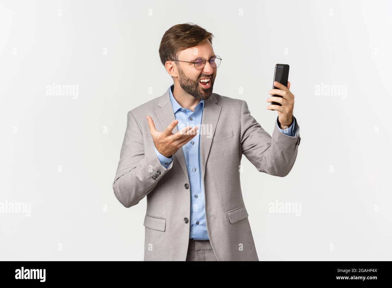 Portrait of businessman in grey suit and glasses, having video call ...