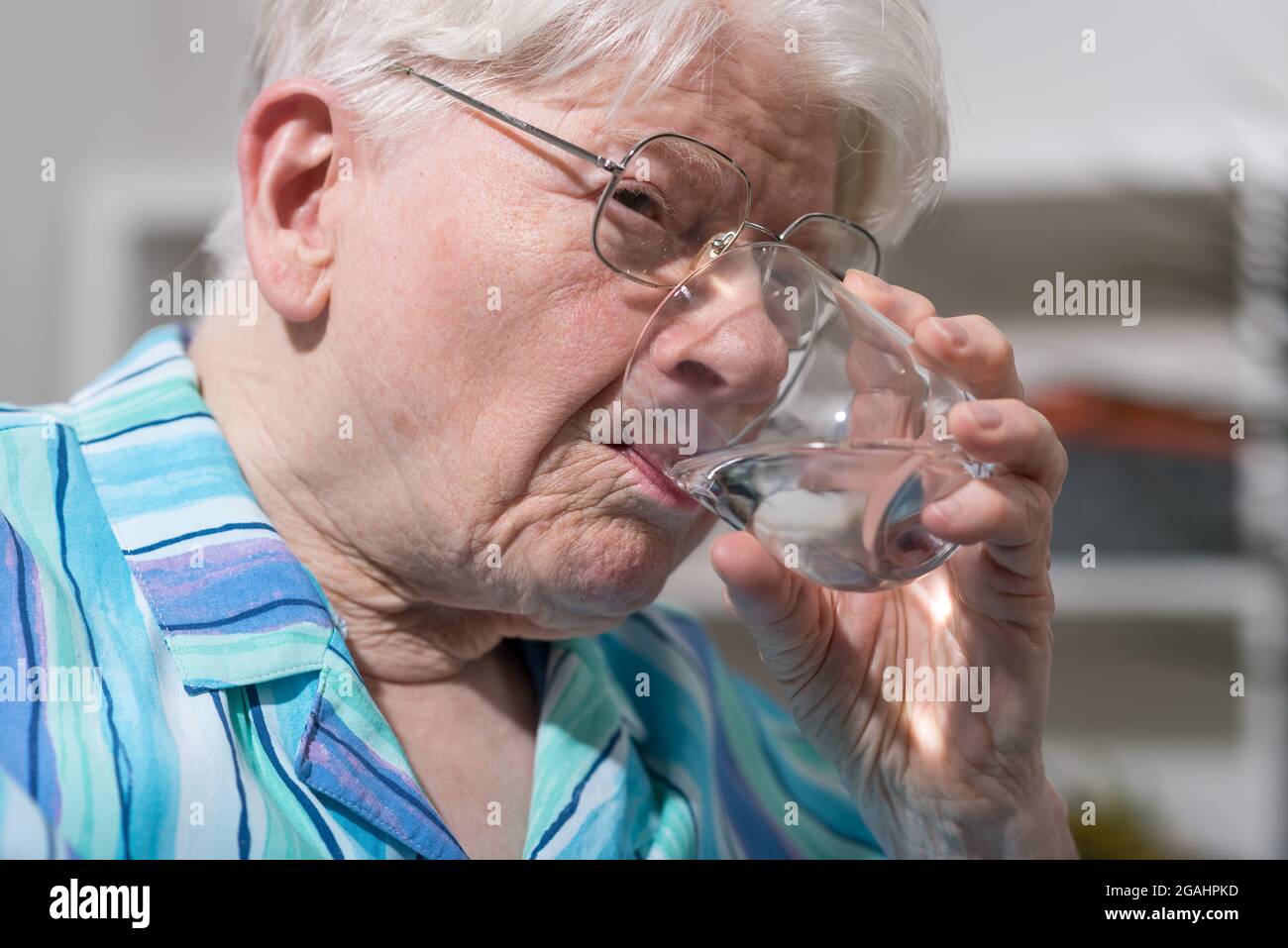 Senior drinking water at home Stock Photo - Alamy