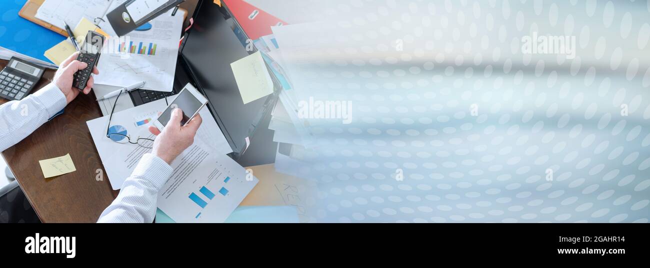 Businessman working at an untidy and cluttered desk; panoramic banner ...