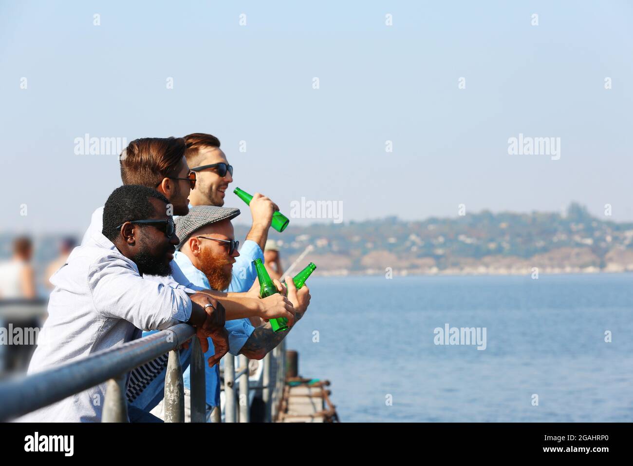 Young men talking on the riverside Stock Photo - Alamy