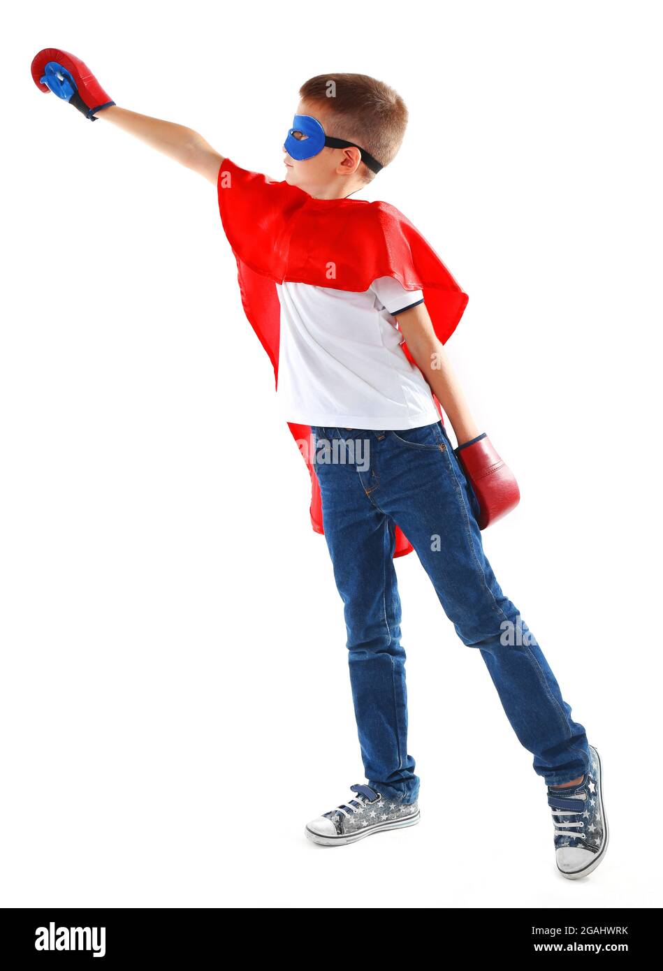 Boy dressed as superhero with boxing gloves poses in studio isolated on ...