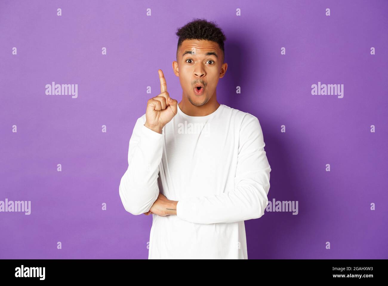 Image of young african-american guy having an idea, raising finger in ...