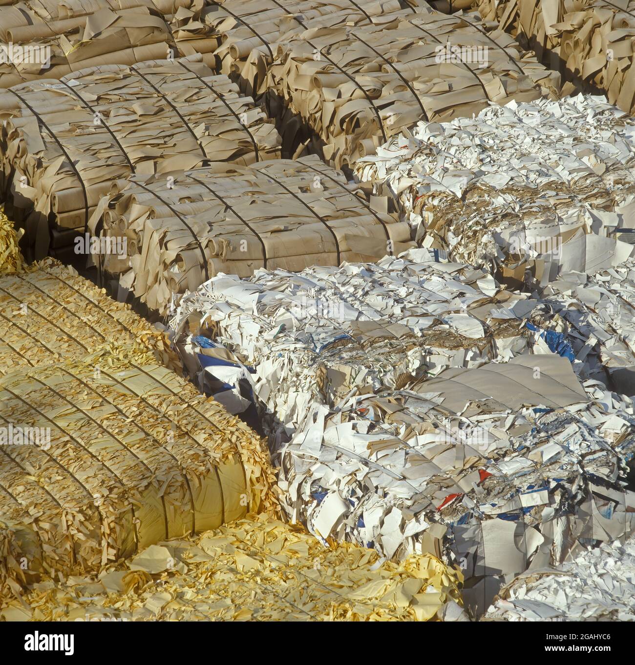 Post consumer waste industrial size paper bails outdoors in dappled ...