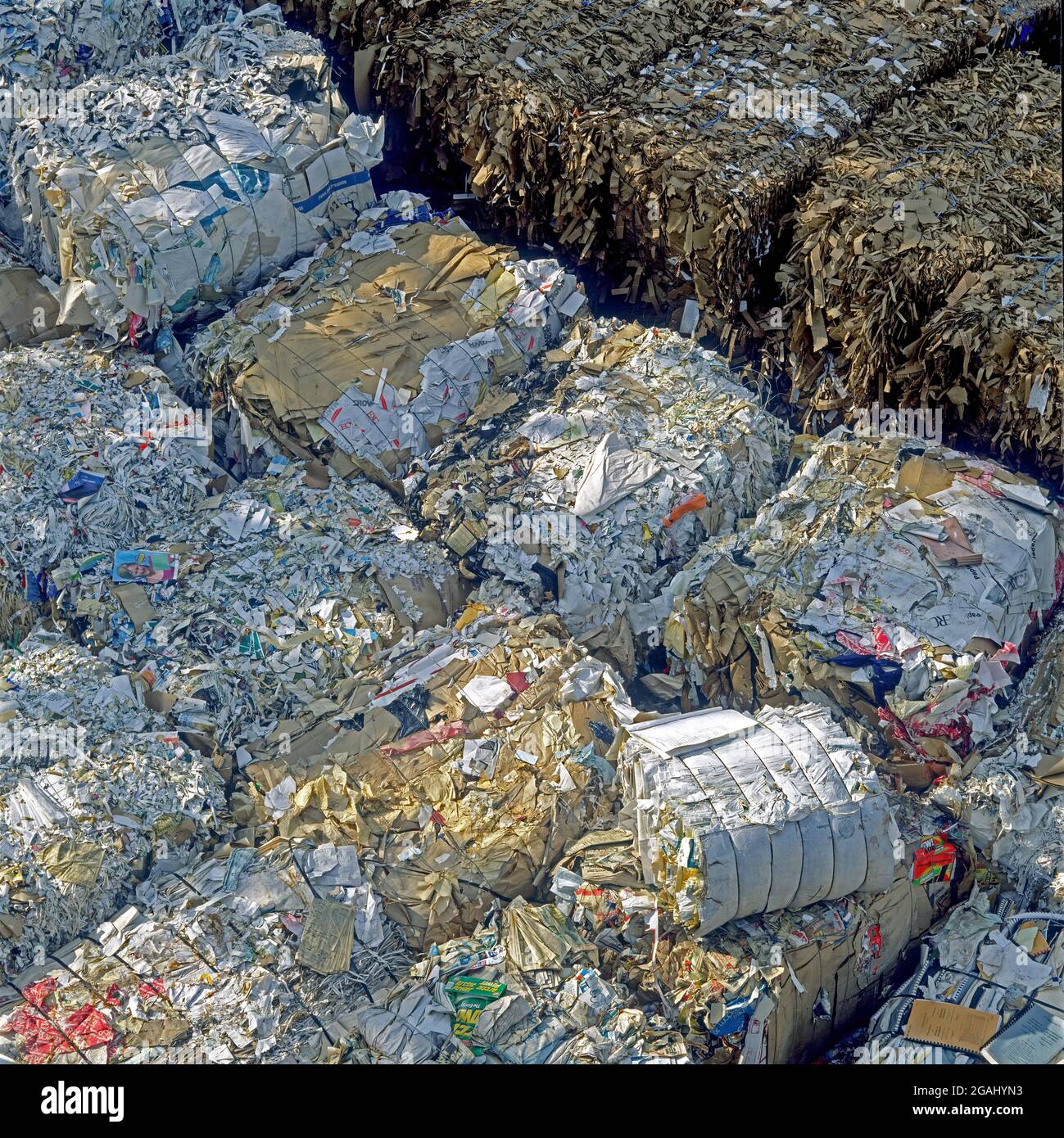 Post consumer waste industrial size paper bails outdoors in dappled ...