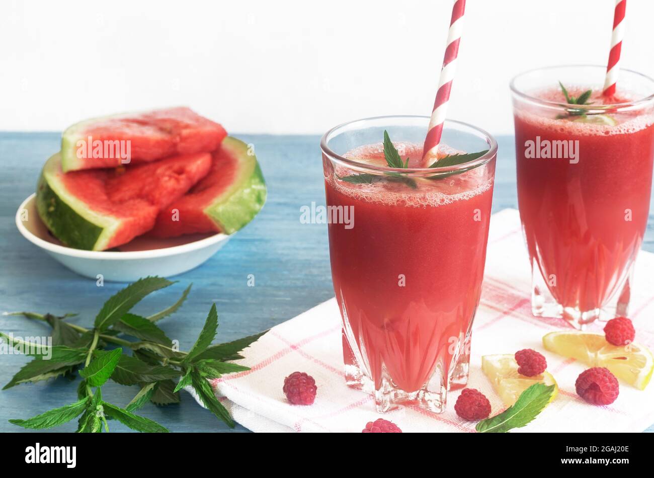 Fresh watermelon juice with raspberries and lemon in a glass. Slices of ...