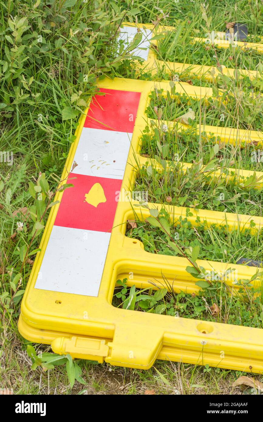 Section of temporary yellow high viz construction site fencing lying on ...