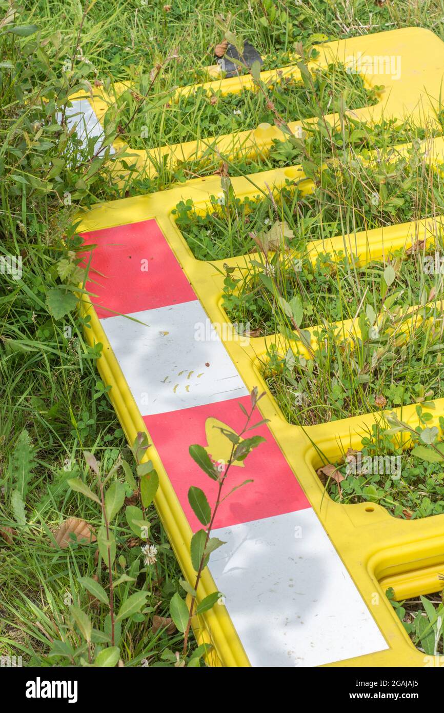 Section of temporary yellow high viz construction site fencing lying on ...