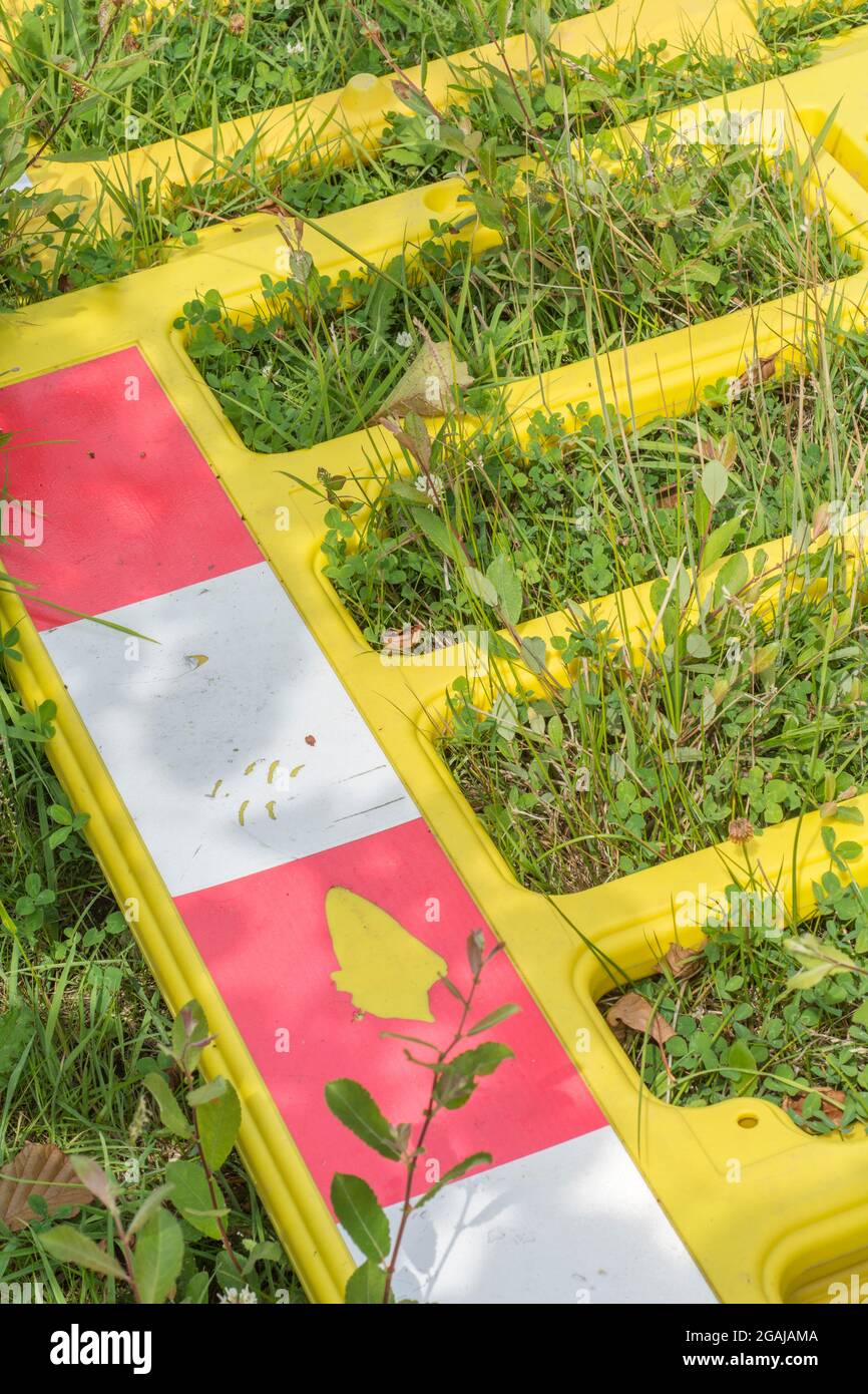 Section of temporary yellow high viz construction site fencing lying on ...