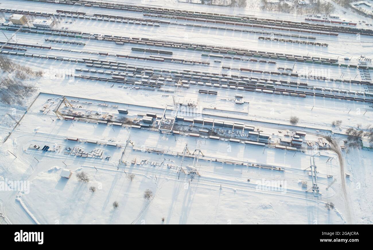 Railroad cargo terminal hub in winter snow time aerial above top drone ...