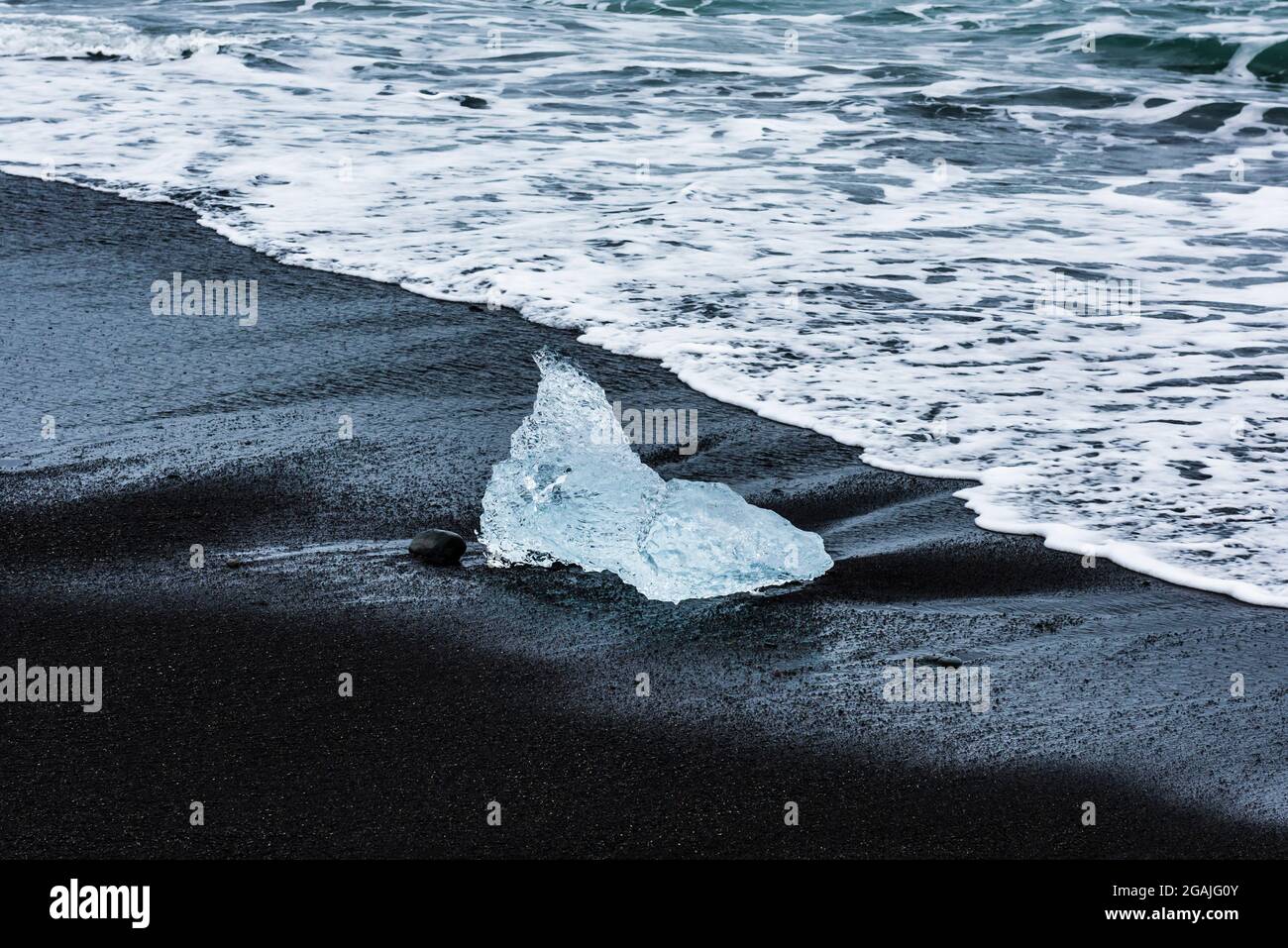 Ice block by the surf on Diamond Beach, Jokulsarlon, Iceland Stock ...