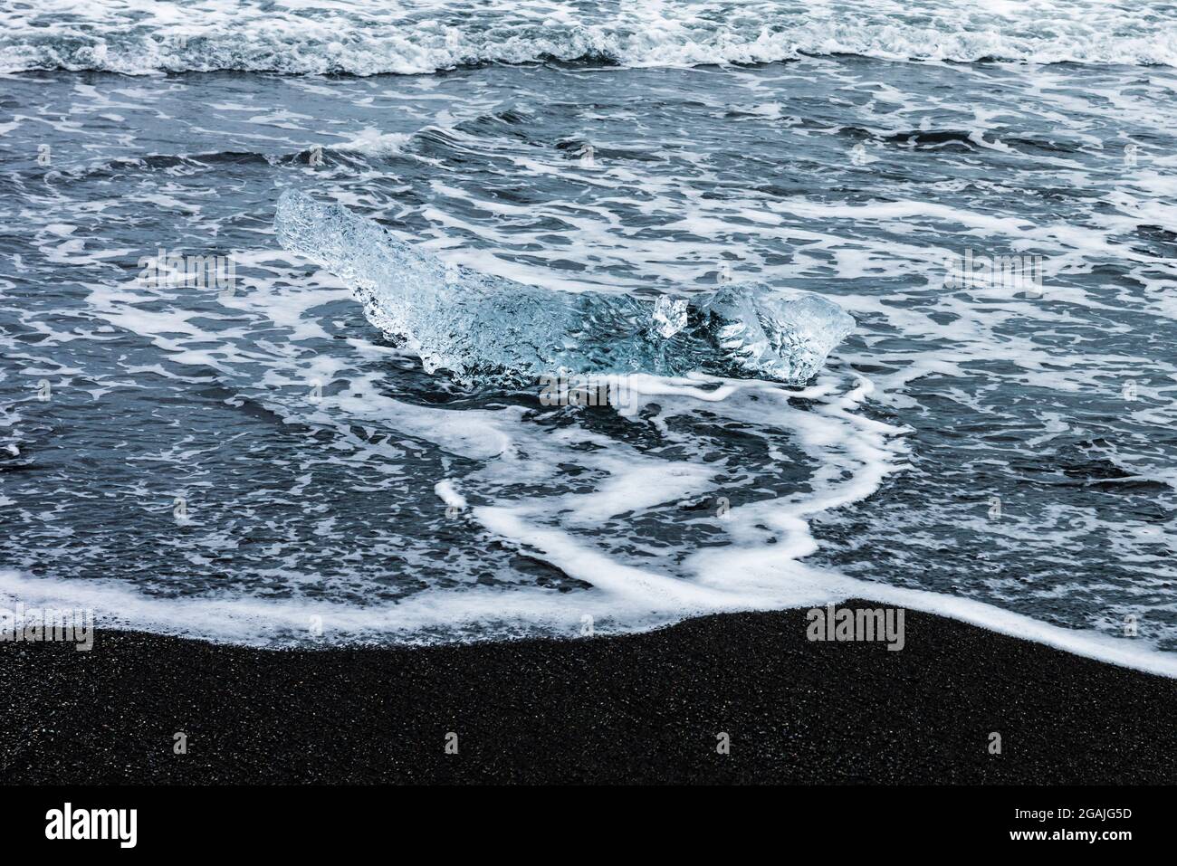Ice block in the surf on Diamond Beach, Jokulsarlon, Iceland Stock ...