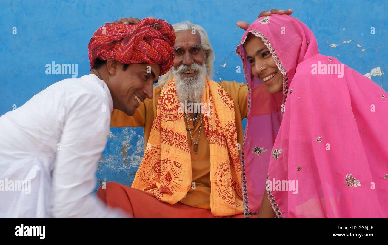 Wise elderly male blessing two young Indian people in traditional ...
