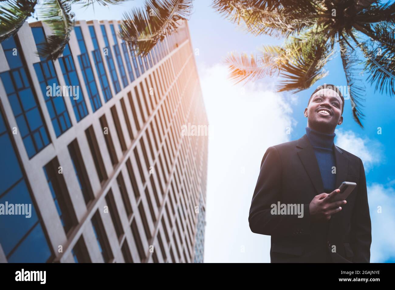 African business man in a suit at a luxurious tropical beachfront hotel ...