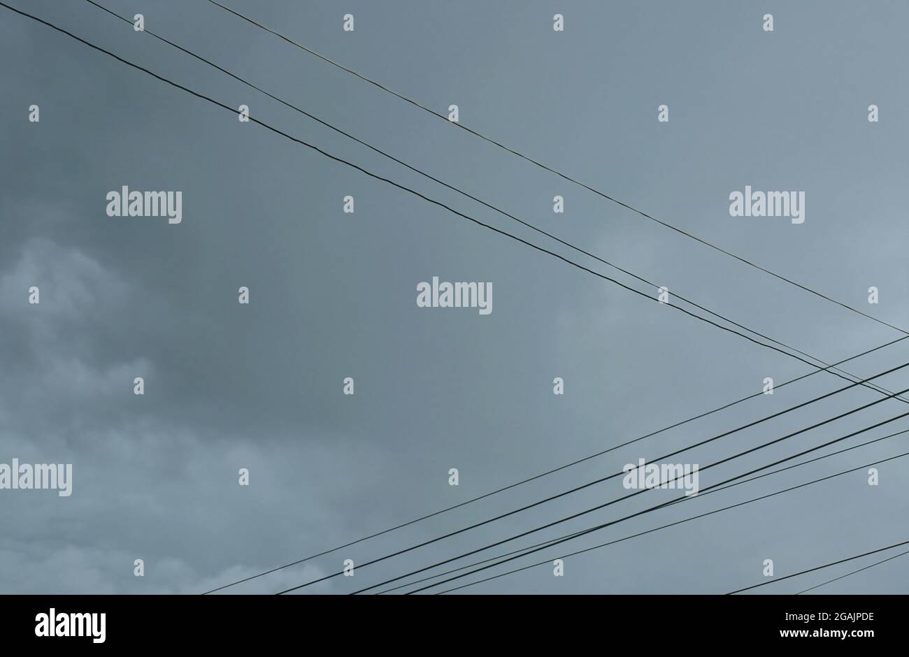 electric cable wire intersection with dark rain cloud on sky background ...