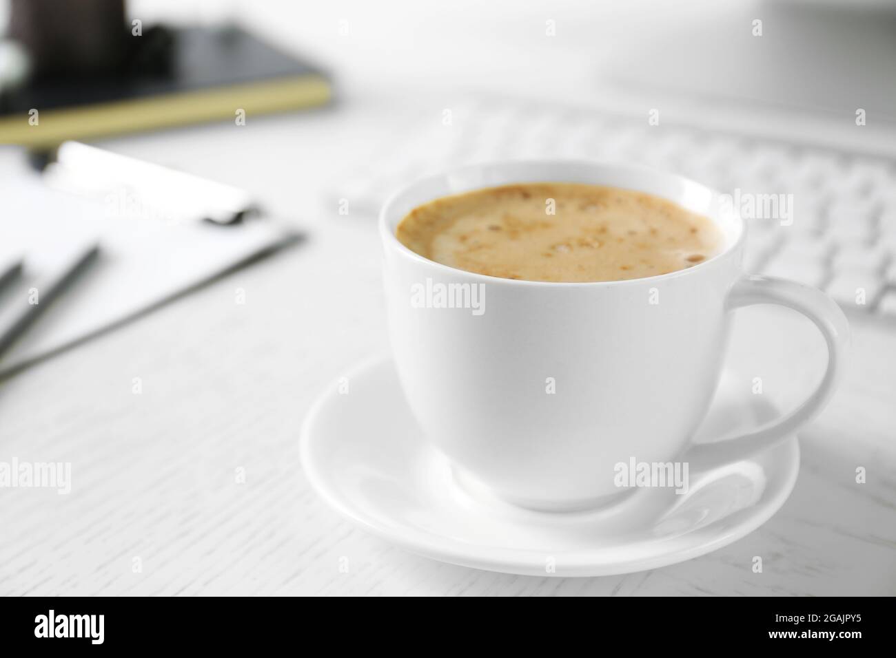 Cup of coffee on workplace background Stock Photo - Alamy