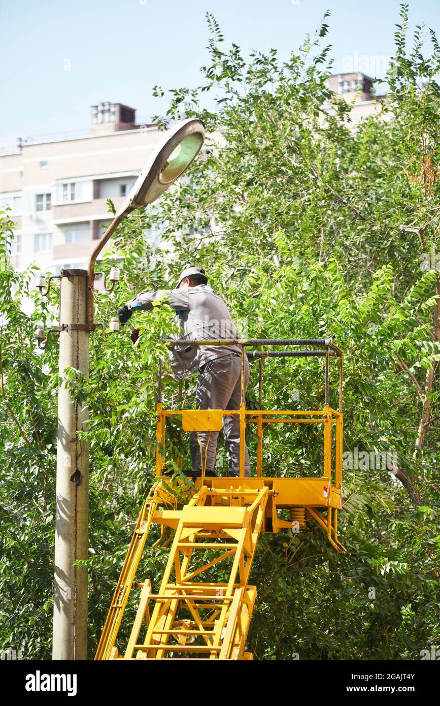 An aerial platform worker changes a lamp in a street lamp Stock Photo ...