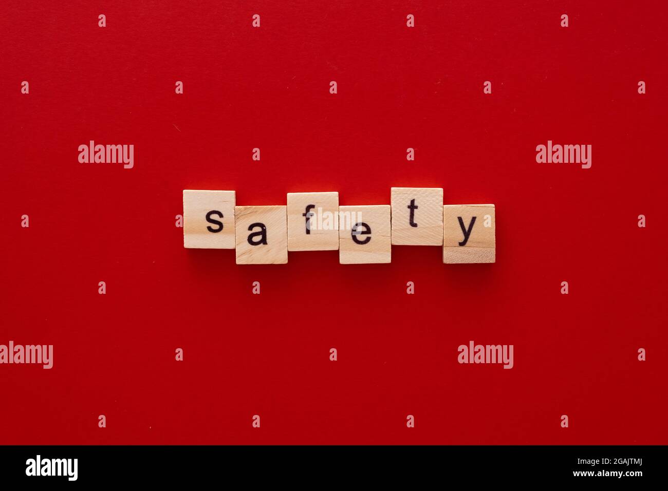 word SAFETY made of wooden letters on red background with copy space ...