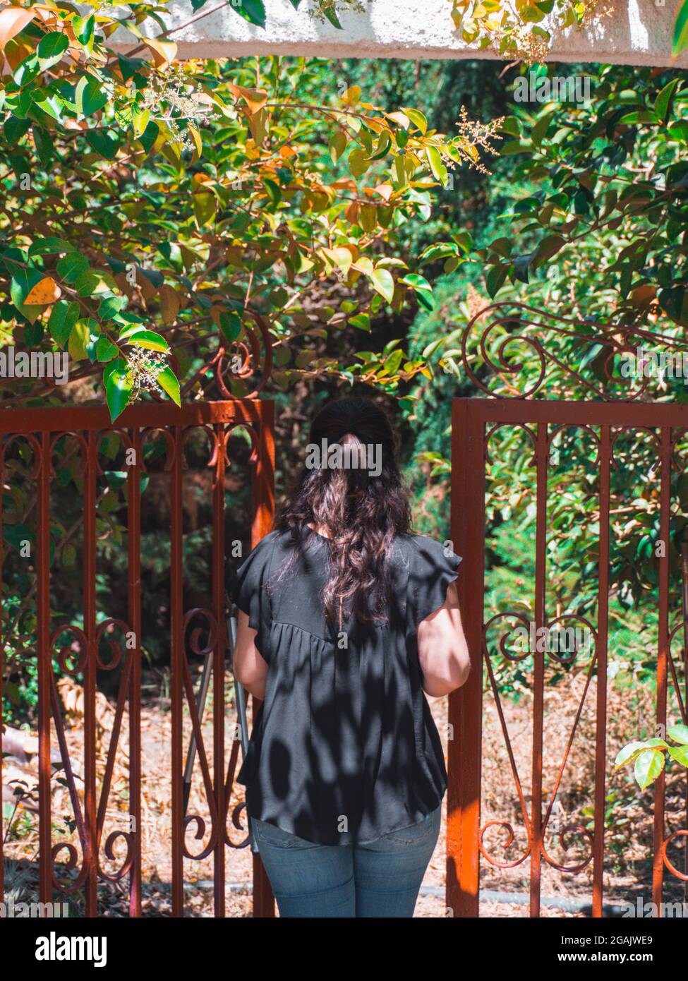Vertical shot of a female entering the garden through a gate Stock ...