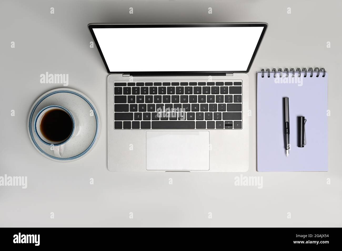 Overhead shot laptop computer, coffee cup and notebook on white office ...