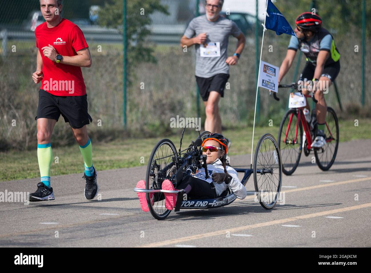 Disabled Athlete who Trains with her Hand Bike with Cyclist and Runners ...