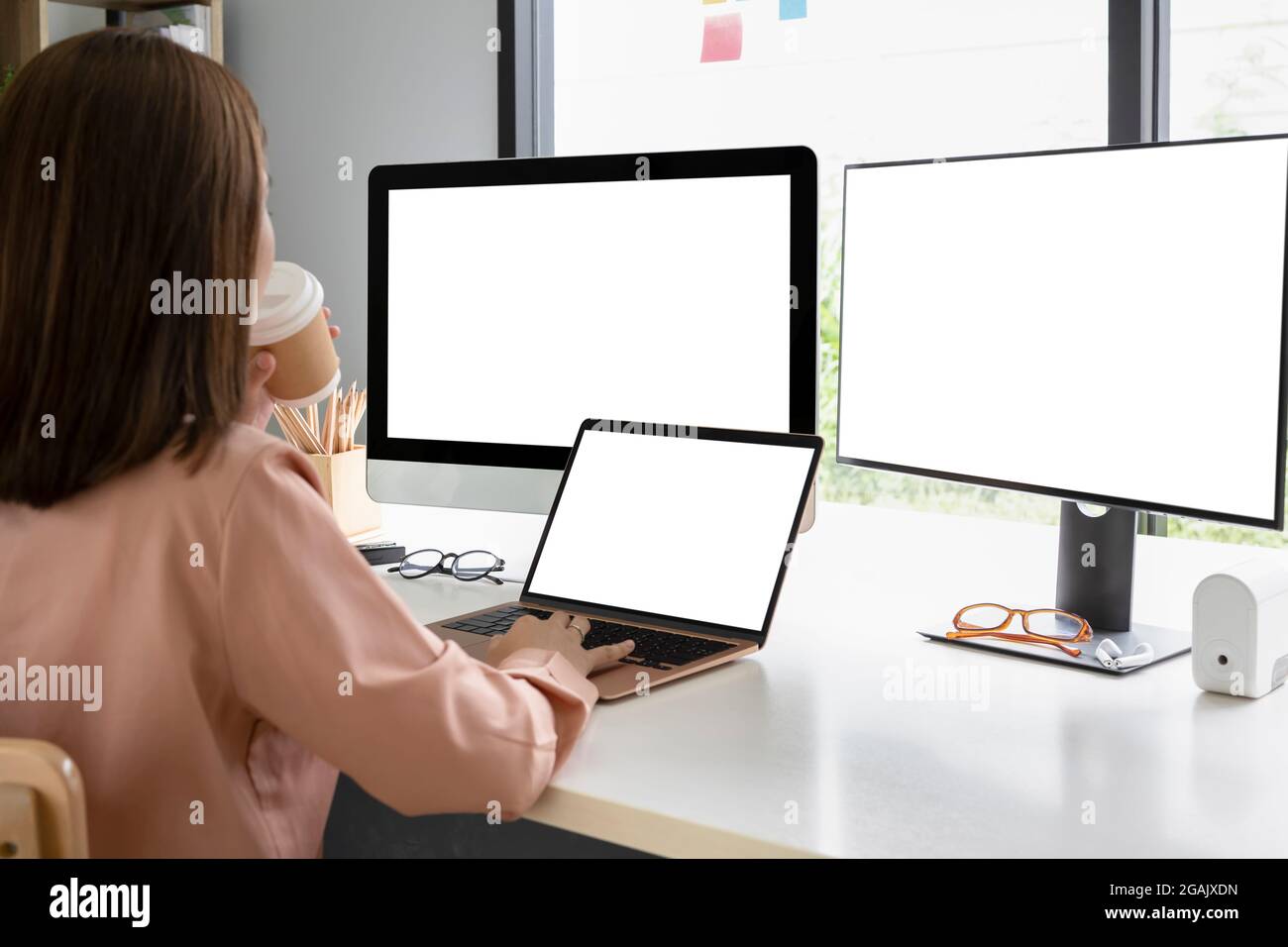 Back view of female working with computer laptop at modern workplace ...