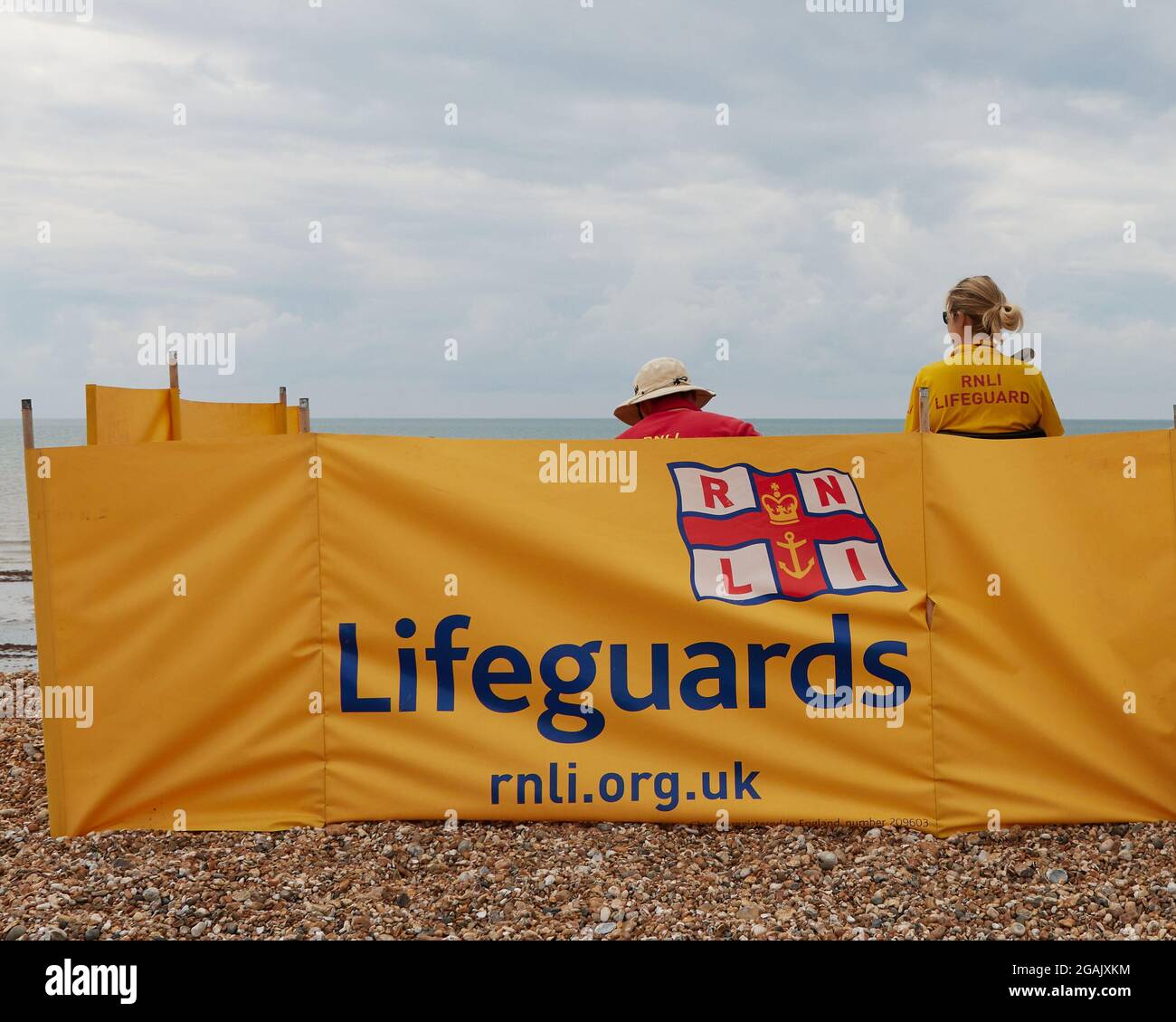 RNLI lifeguards and logo seen on the beach Stock Photo - Alamy