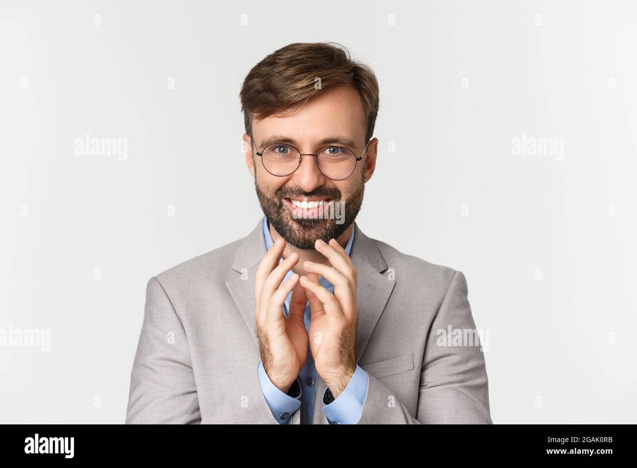 Close-up of bearded businessman in glasses and suit, scheming something ...