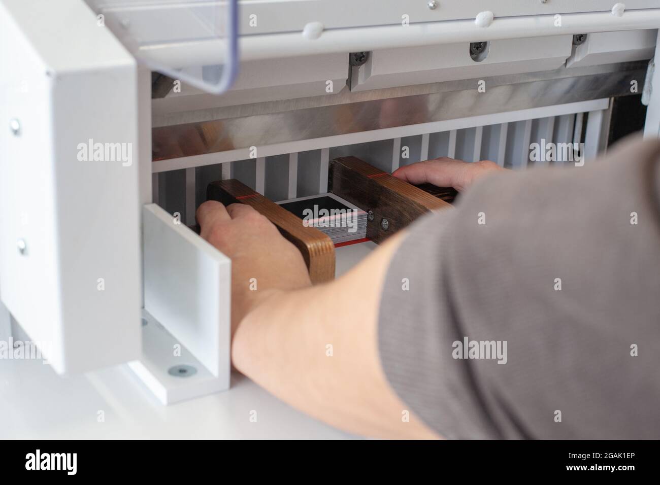 two man hands align a stack of business cards or tags with wooden ...