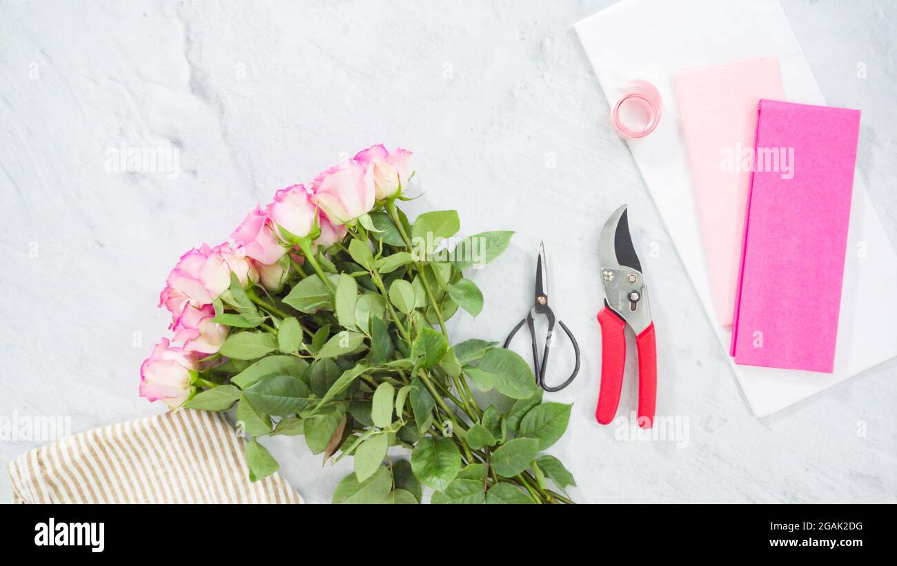 Flat lay. Step by step. Florist arranging a bouquet from pink roses ...