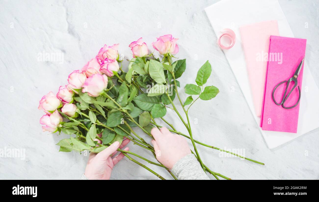 Flat lay. Step by step. Florist arranging a bouquet from pink roses ...