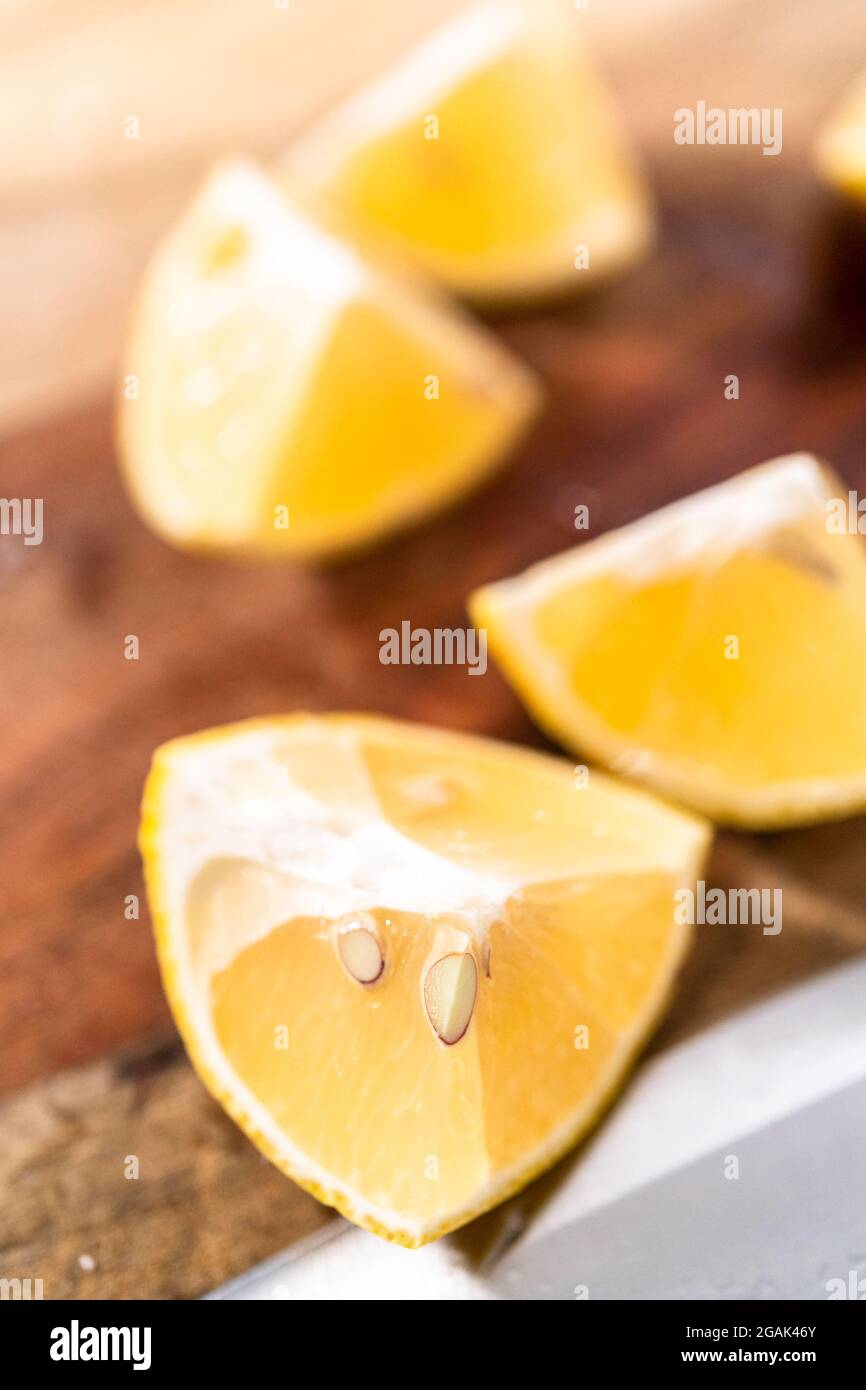 Cutting organic lemon on a wood cutting board Stock Photo - Alamy